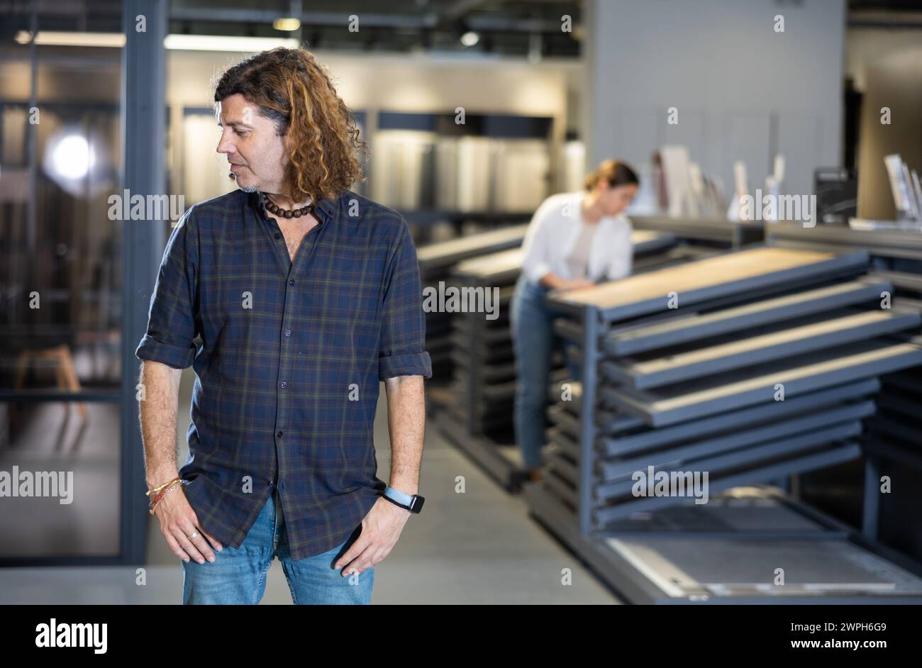 Confident male customer looking around in bathroom material section of ...