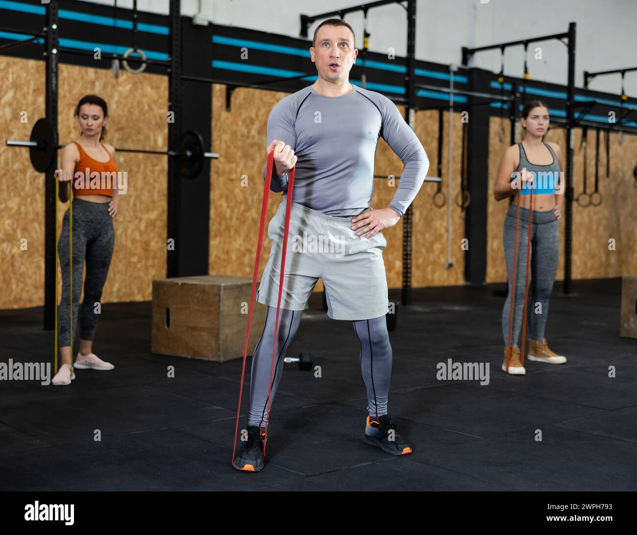 Strong man using resistance band in exercise routine in crossfit gym ...