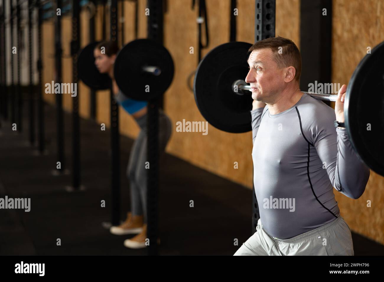 Man trains muscles of arms and back using barbell and differentiated ...