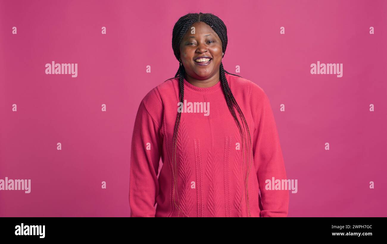 Stunning african american lady in pink stylish outfit laughing for ...