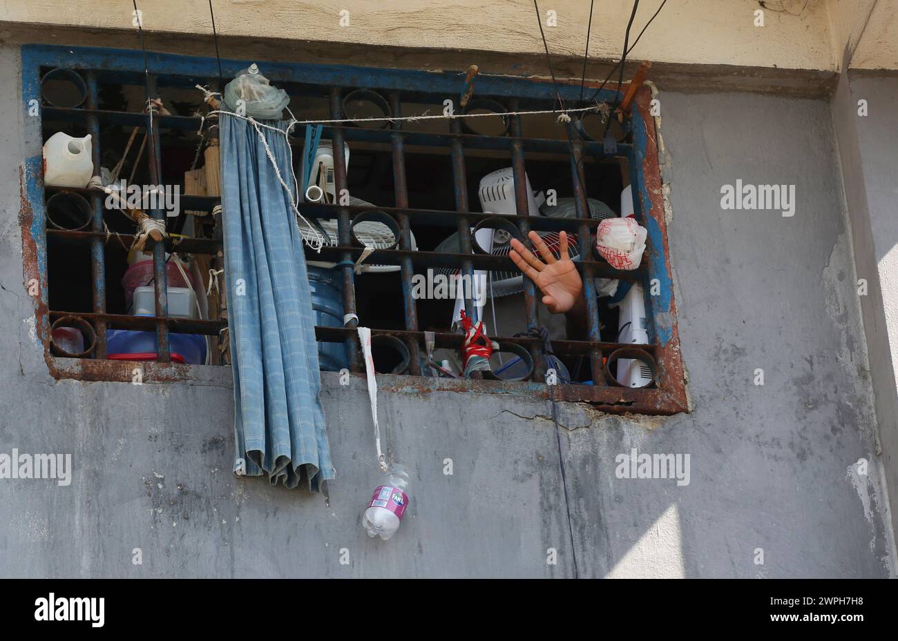 An inmate waves at the National Penitentiary in Port-au-Prince, Haiti ...