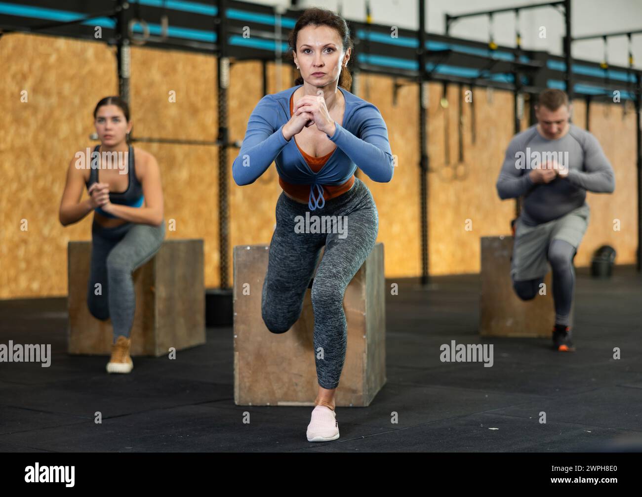 Fit young woman box jumping at crossfit style in gym class. Fitness ...