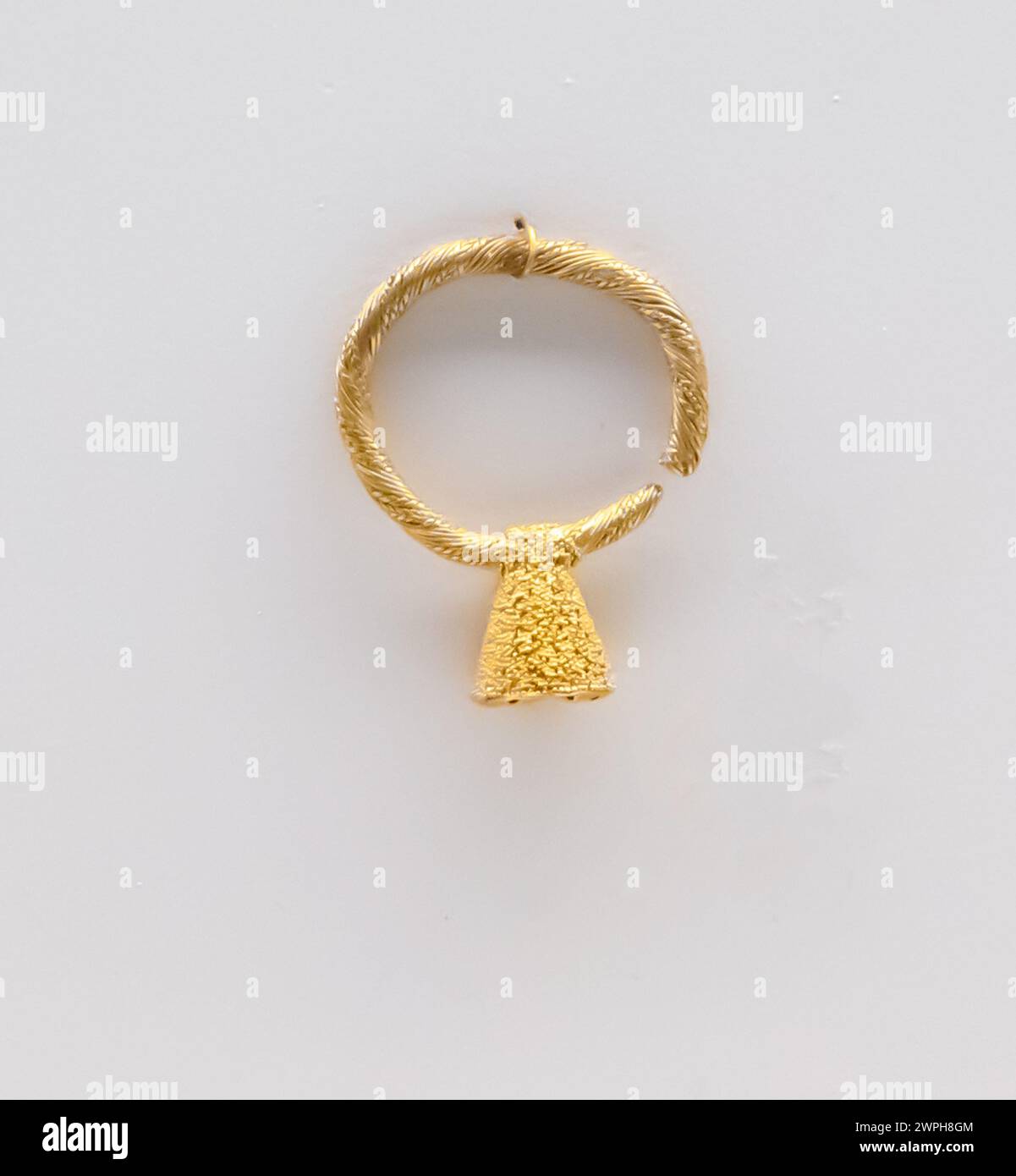 A gold earring with a cone-shaped pendant, decorated with granulation ...