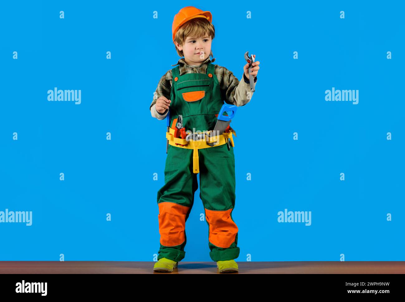 Little builder boy playing with toy adjustable wrench. Child game ...