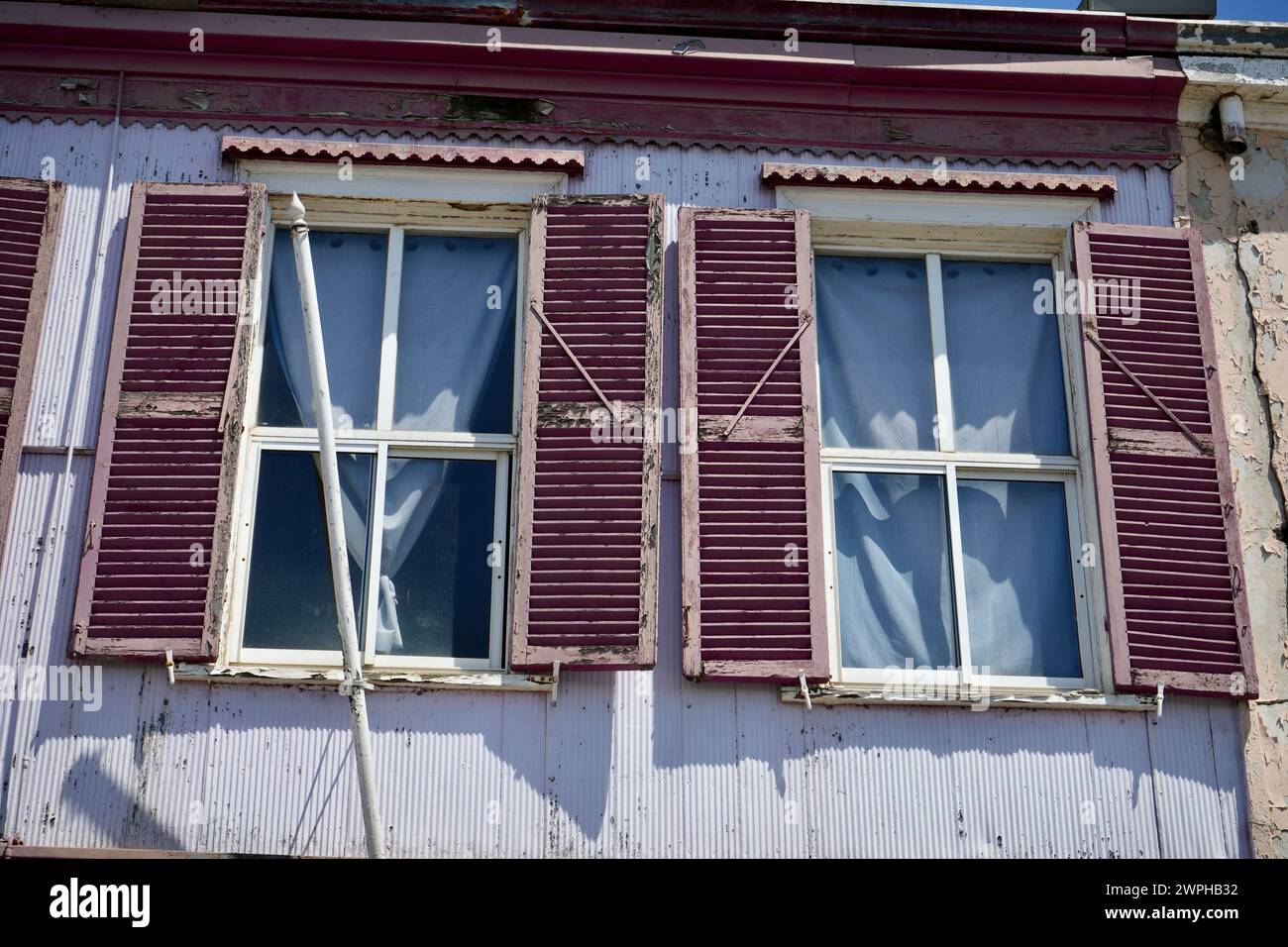 Rustic mauve shuttered windows on a corrugated metal building in the ...