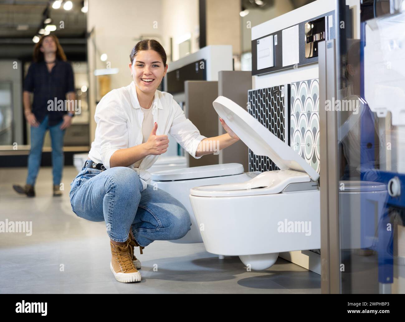 Confident female customer choosing new toilet in hardware store Stock ...