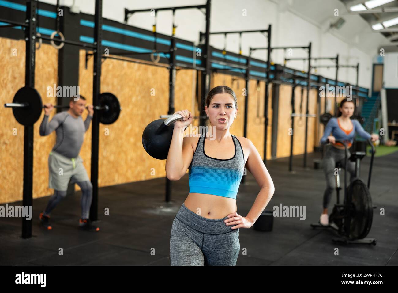 Happy fit sweaty girl exercising with kettlebell, doing cross fit ...