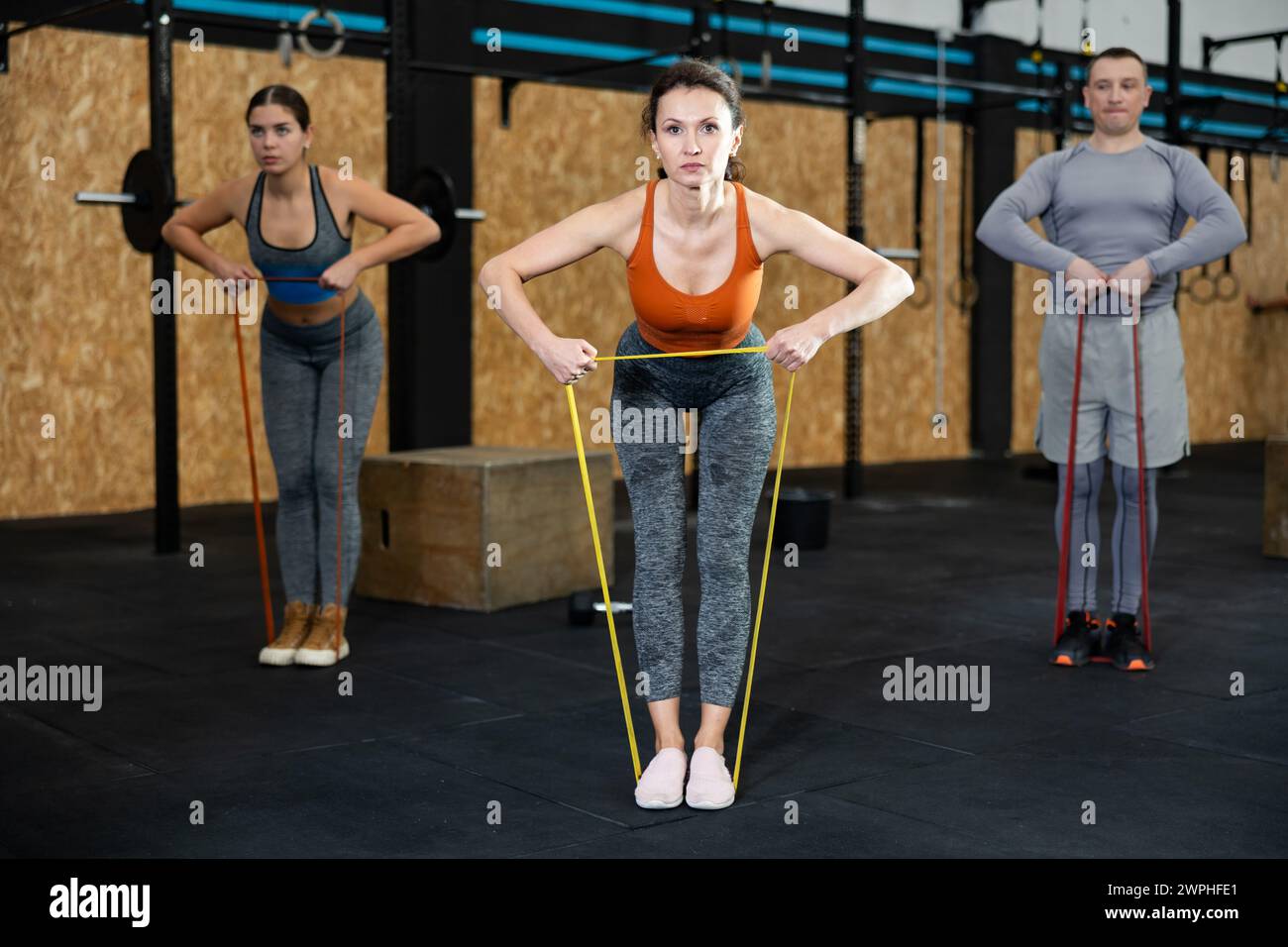 Woman during grueling workout with rubber band in sports hall fitness ...