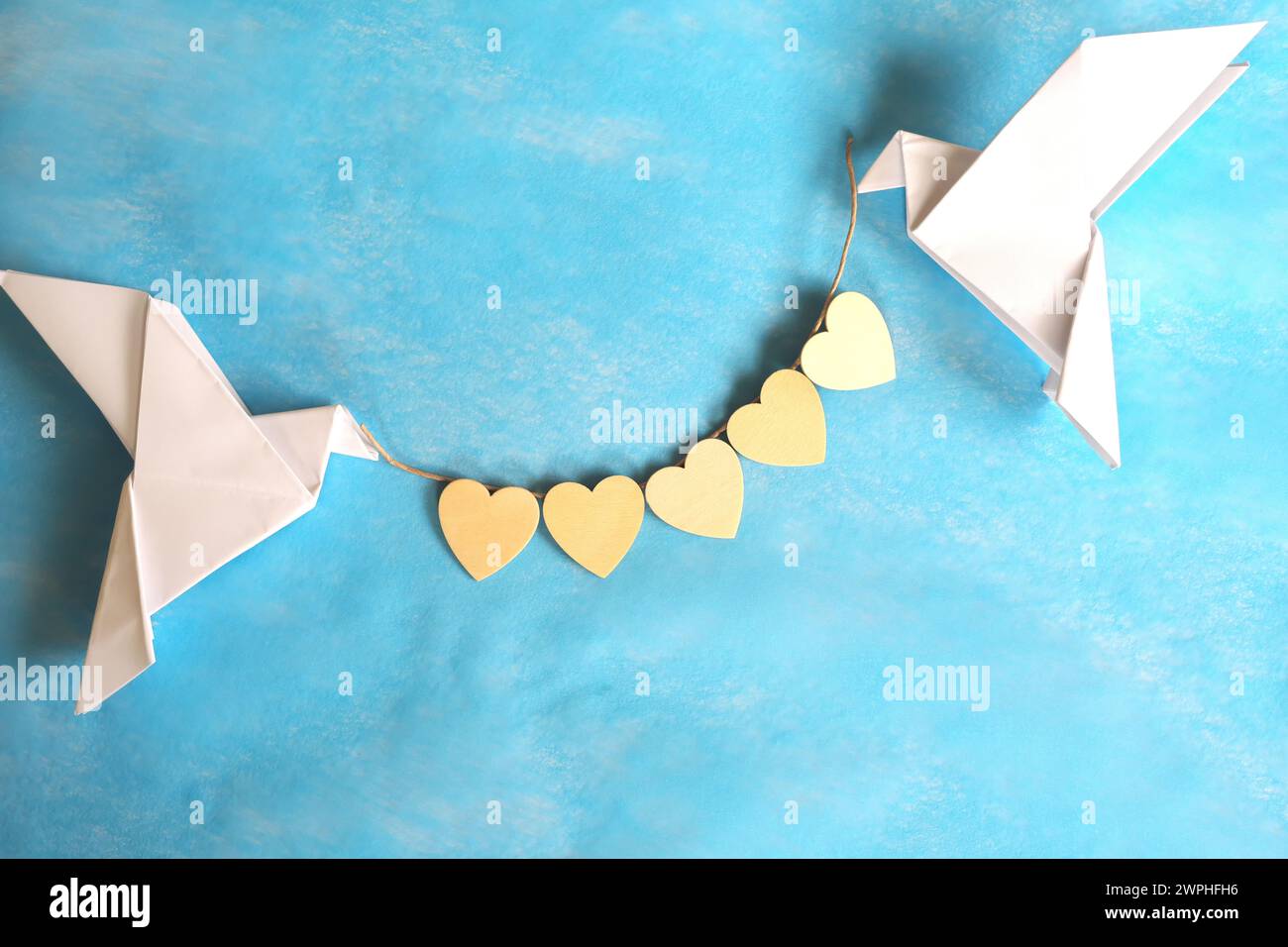 Message of love and kindness. Two white dove origami carrying heart ...