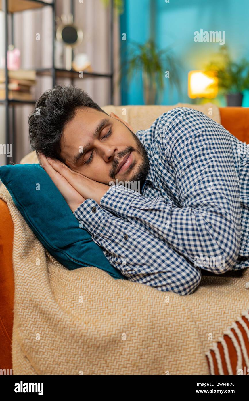 Tired Indian young man lying down in bed taking a rest. Carefree ...
