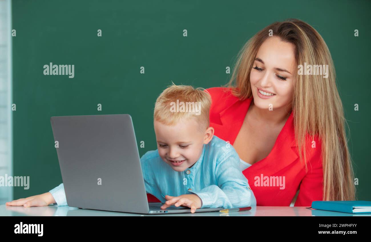 Mother and son together using computer laptop. Teacher explains lesson ...