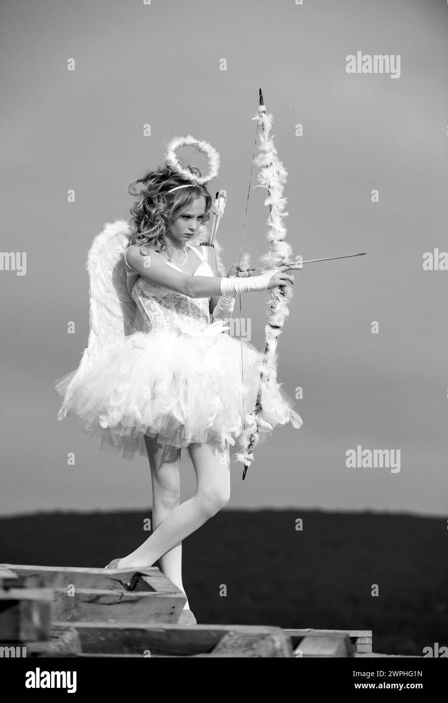 Valentines day cupid. A beautiful teen with blonde curly hair and a bow ...