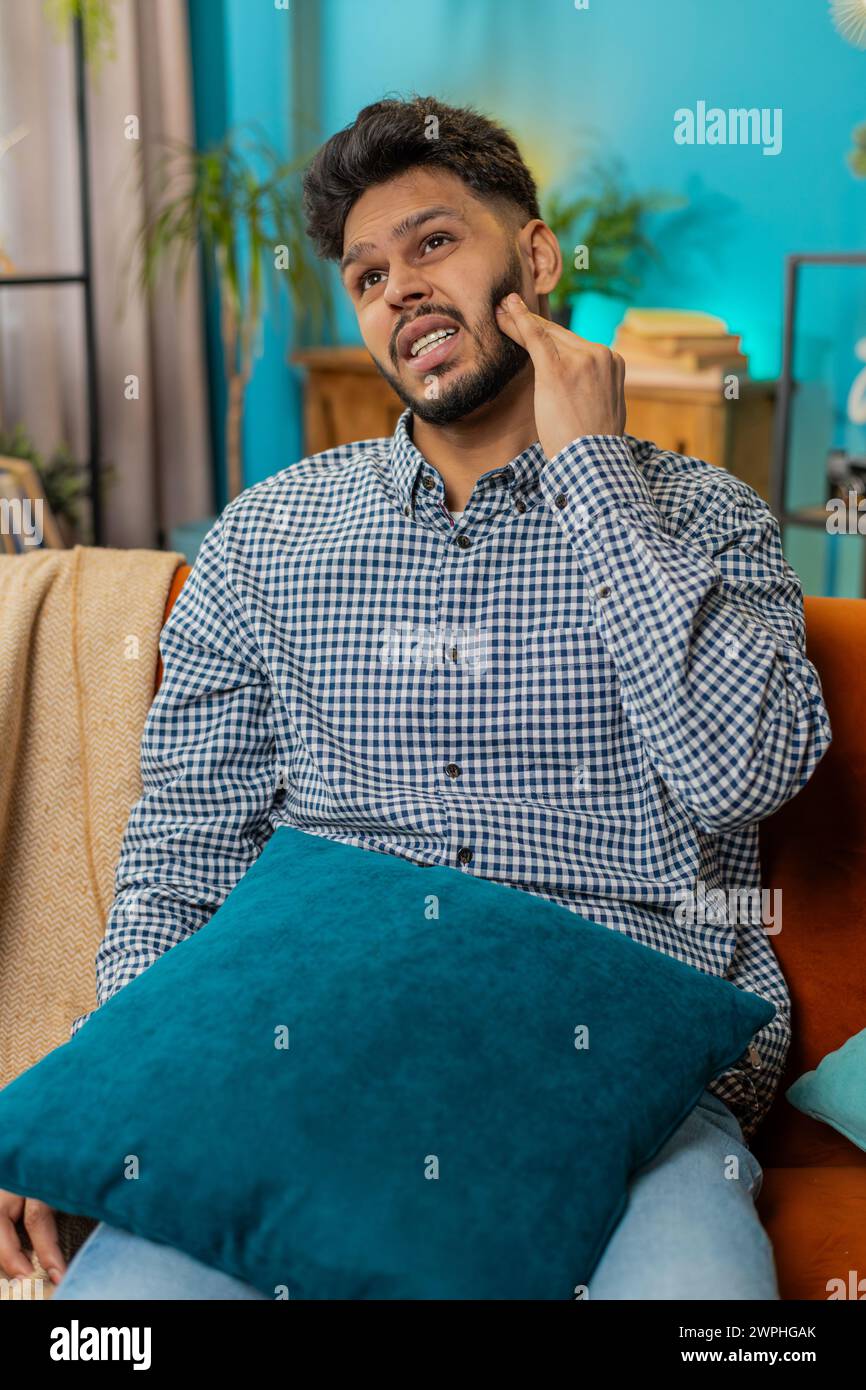 Dental problems. Frustrated sick ill Hindu man touching cheek, closing ...