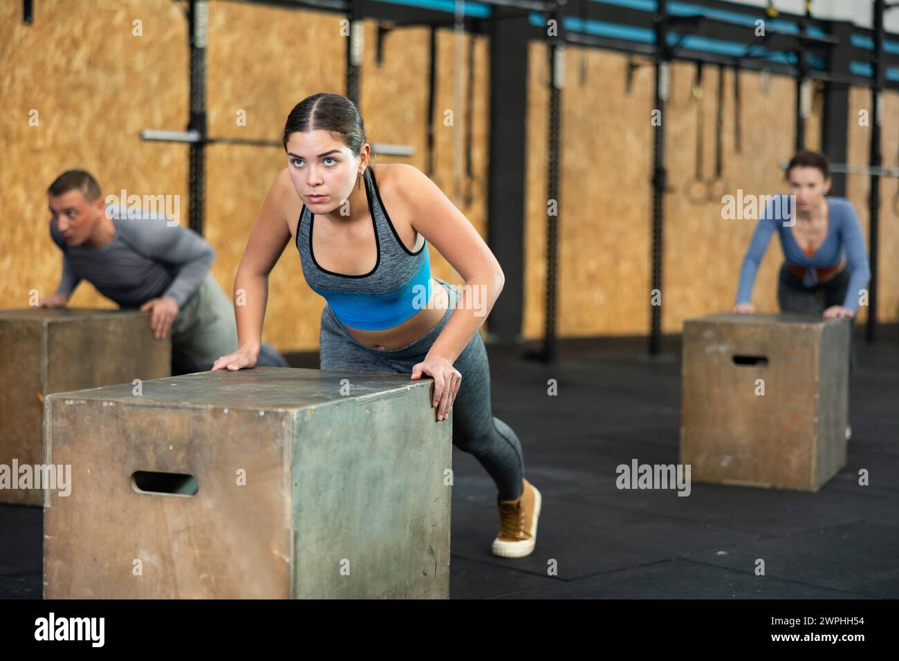 Girl performing incline push-ups on plyometric box at gym Stock Photo ...