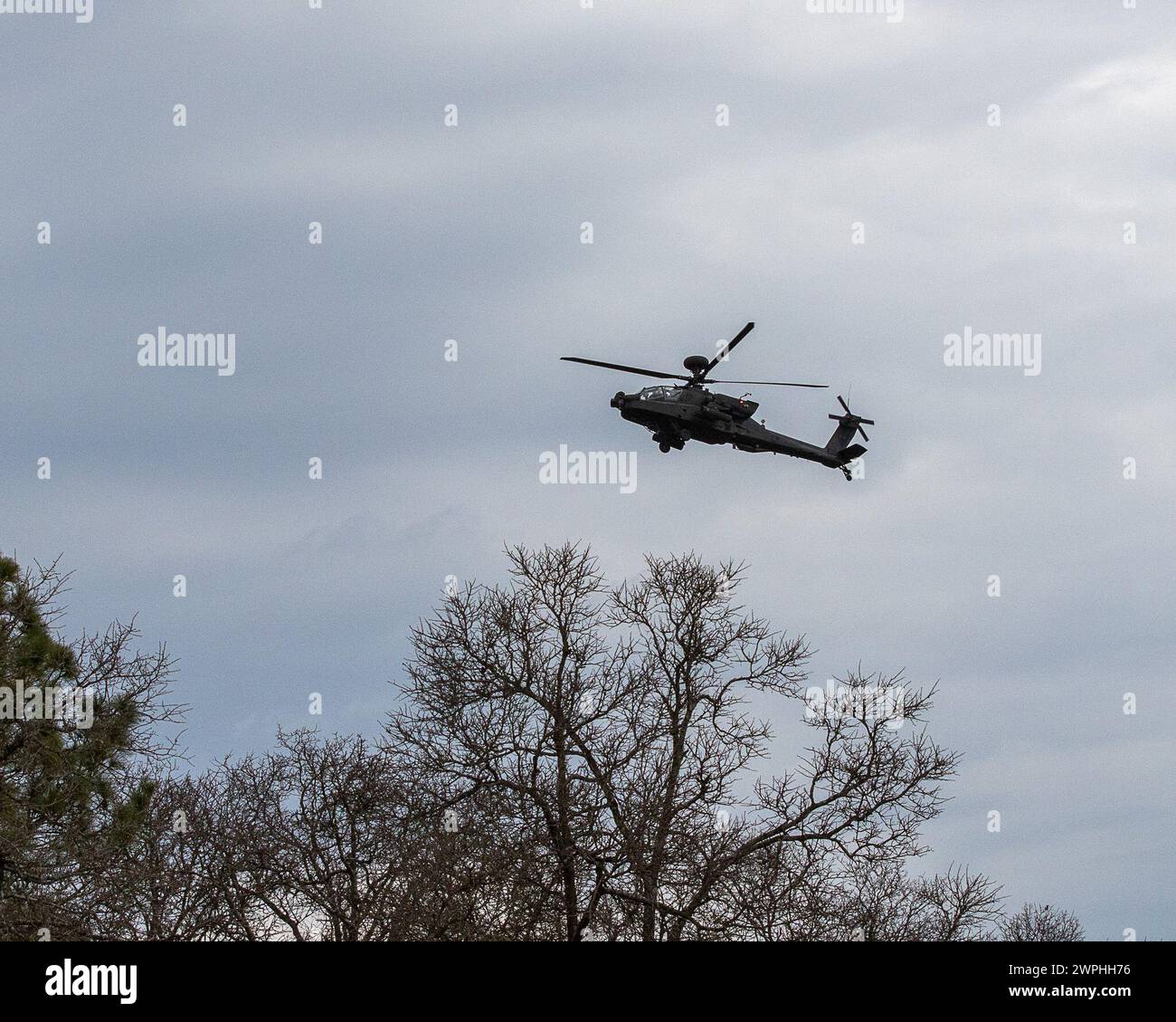 A Boeing AH-64F Apache Helicopter flies overhead to provide aerial ...