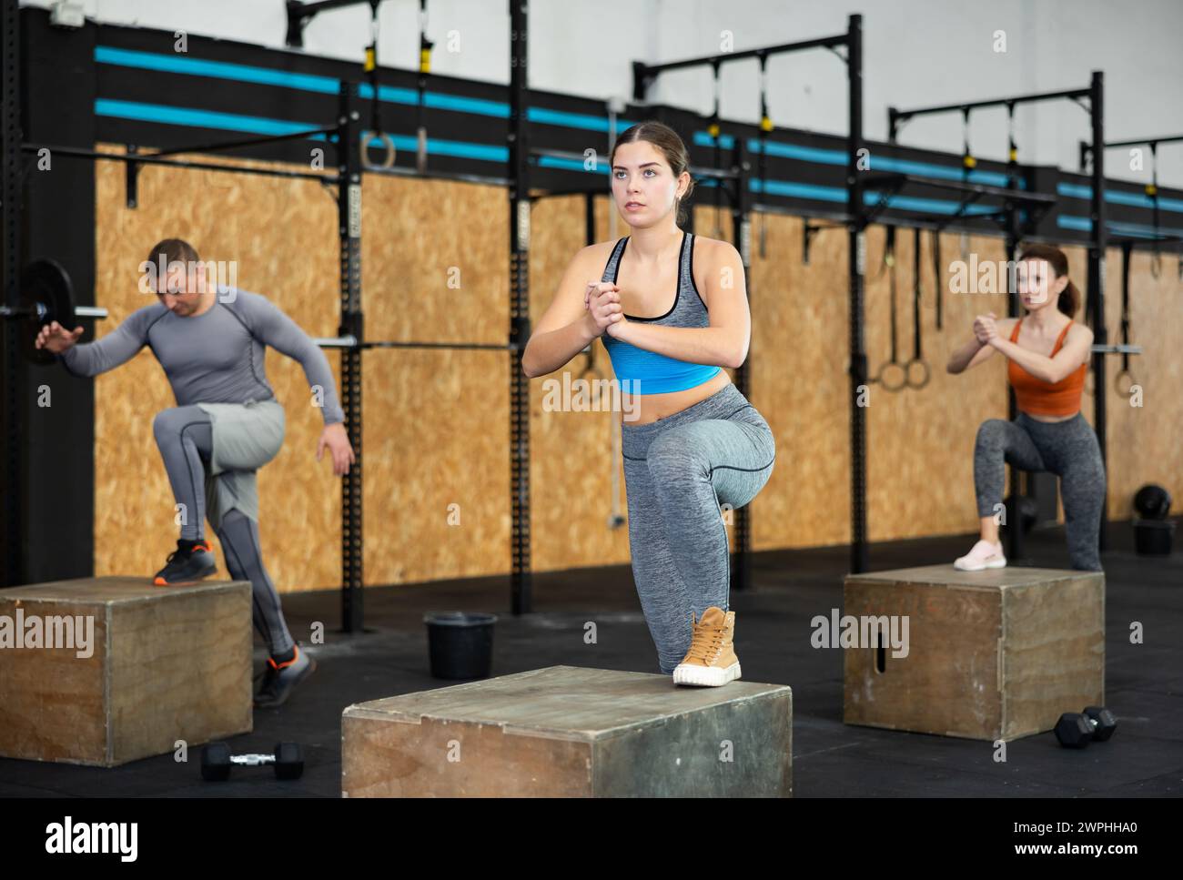 Young woman doing muscle stretching. CrossFit in group with other ...