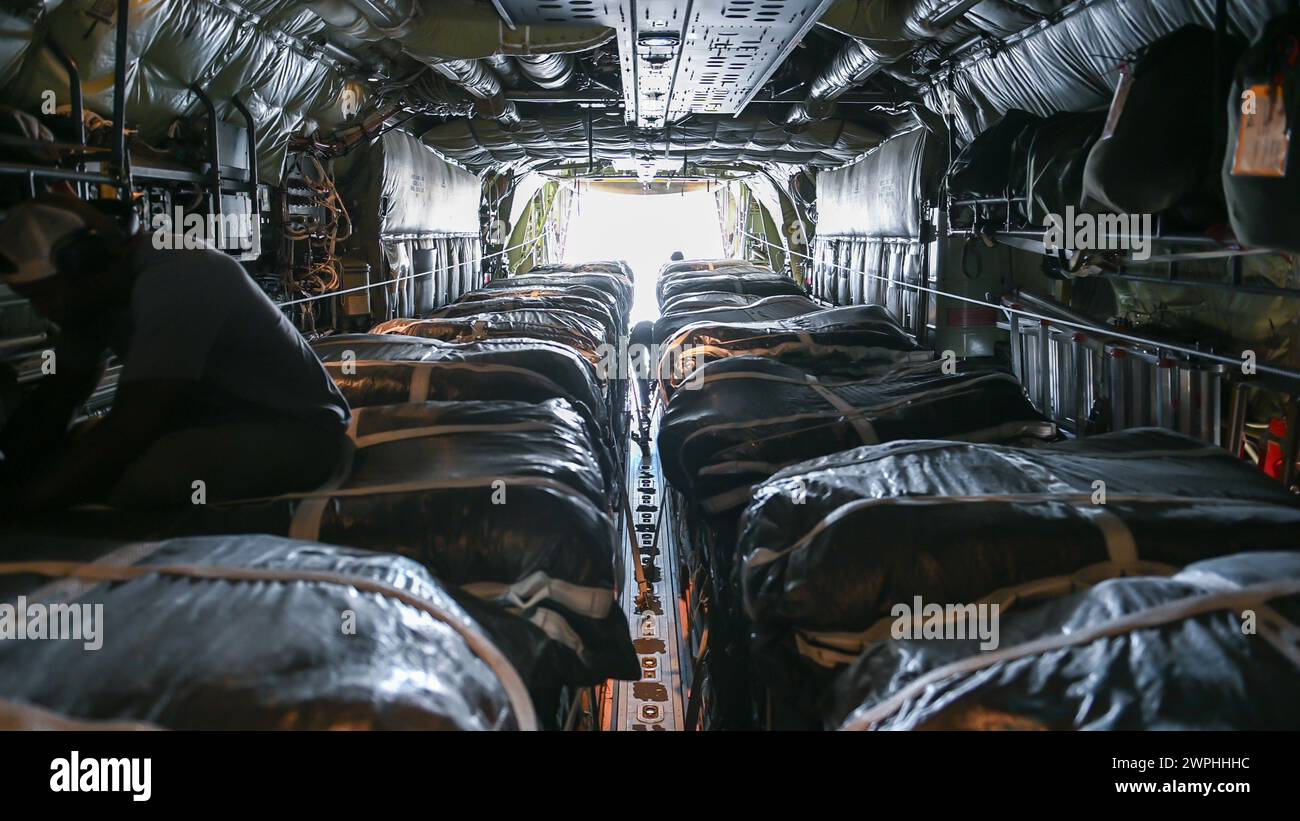 A U.S. Army rigger checks the parachute setup of humanitarian aid ...