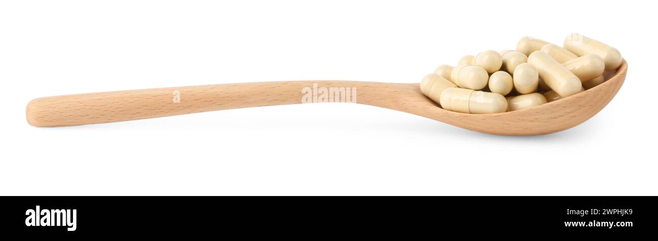 Vitamin capsules in wooden spoon isolated on white Stock Photo - Alamy
