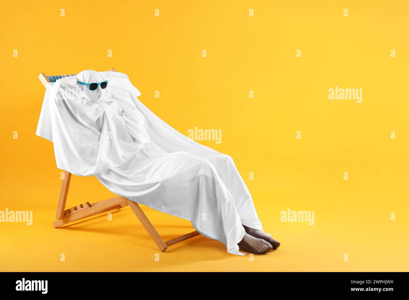 Person in ghost costume and sunglasses relaxing on chaise longue ...