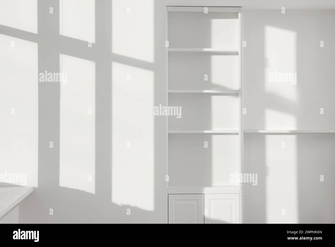 Light and shadows from window on wall and shelving unit indoors Stock ...