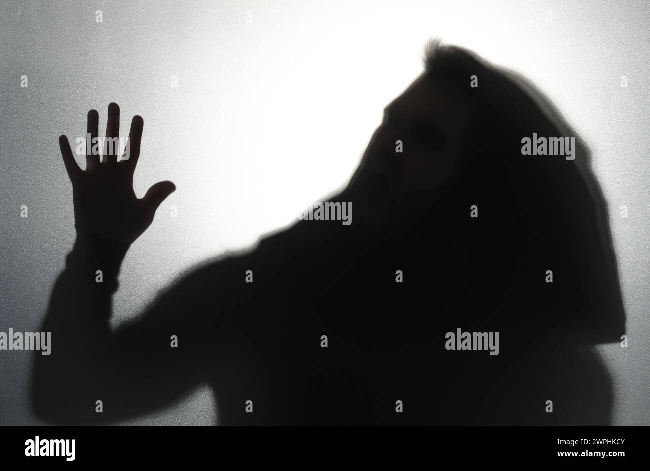 Silhouette of ghost behind glass against light grey background Stock ...