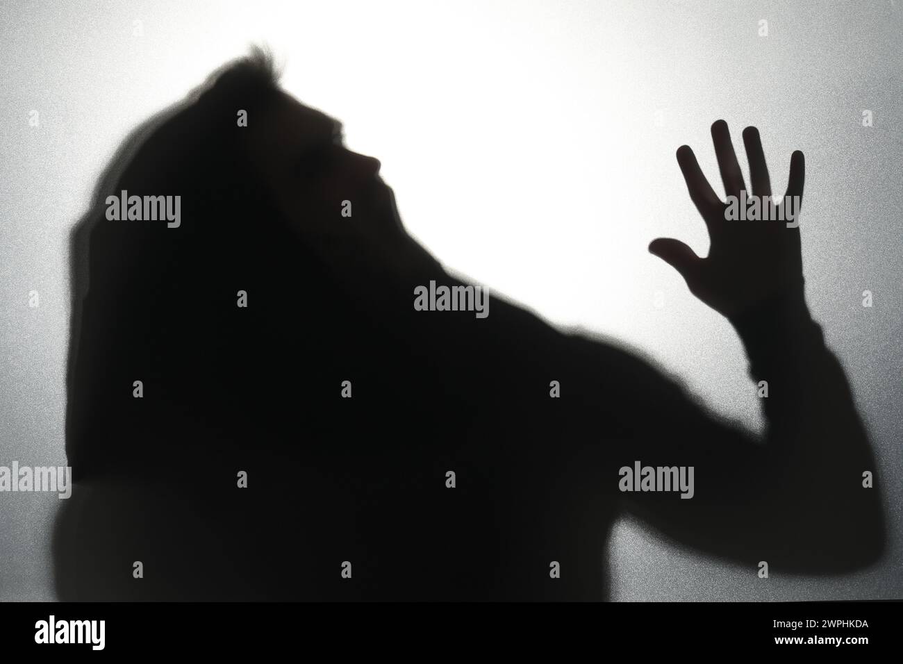 Silhouette of ghost behind glass against light grey background Stock ...