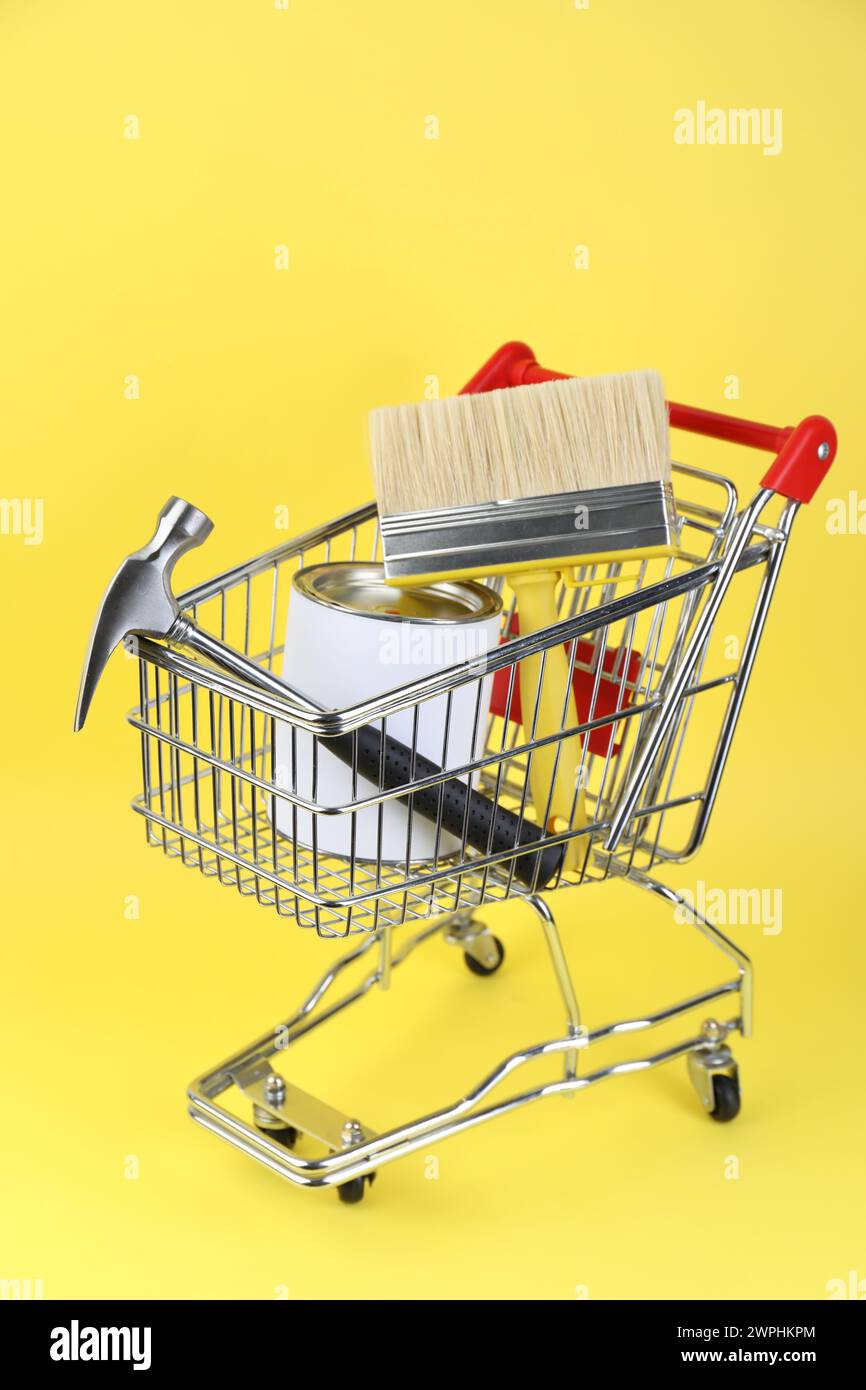 Small shopping cart with paint and renovation equipment on yellow ...