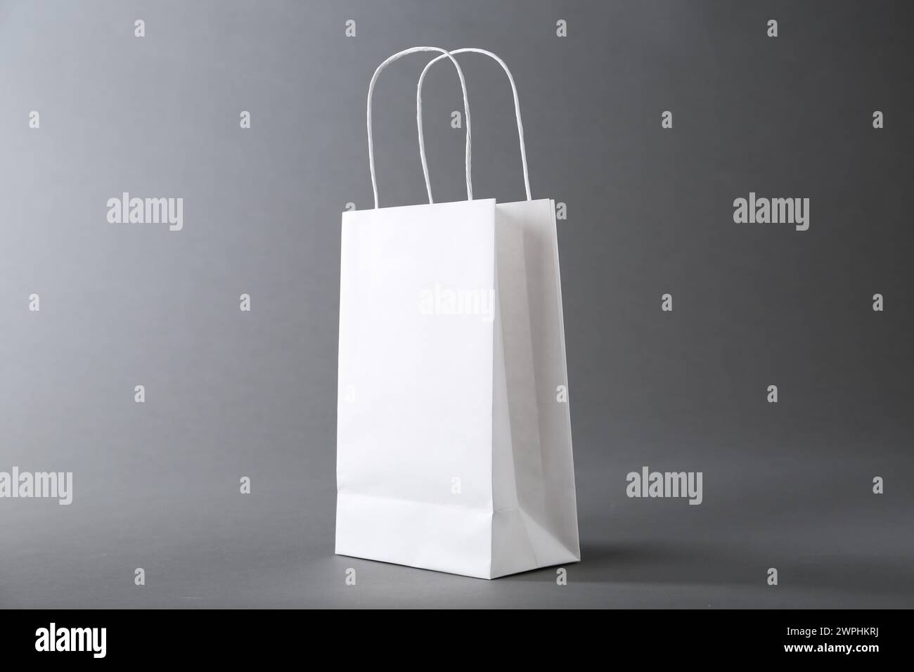 One white paper bag on grey background. Mockup for design Stock Photo ...