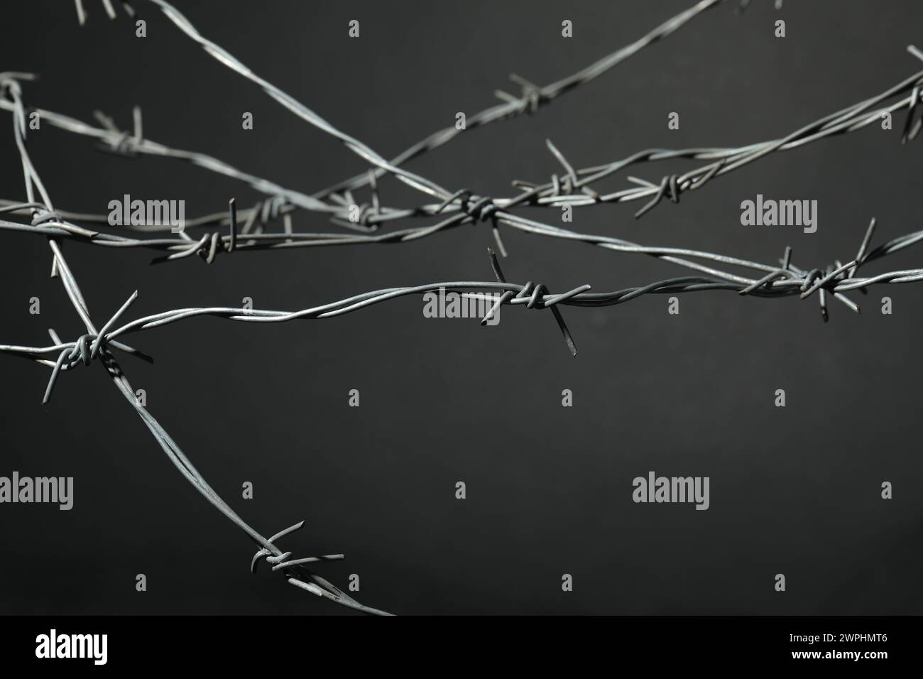 Metal barbed wire on dark grey background Stock Photo - Alamy