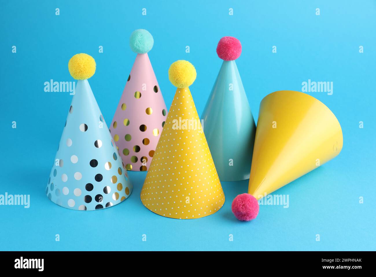 Colorful party hats on light blue background Stock Photo - Alamy