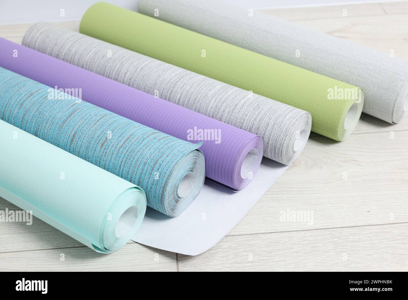 Many different wallpaper rolls on light wooden floor Stock Photo - Alamy