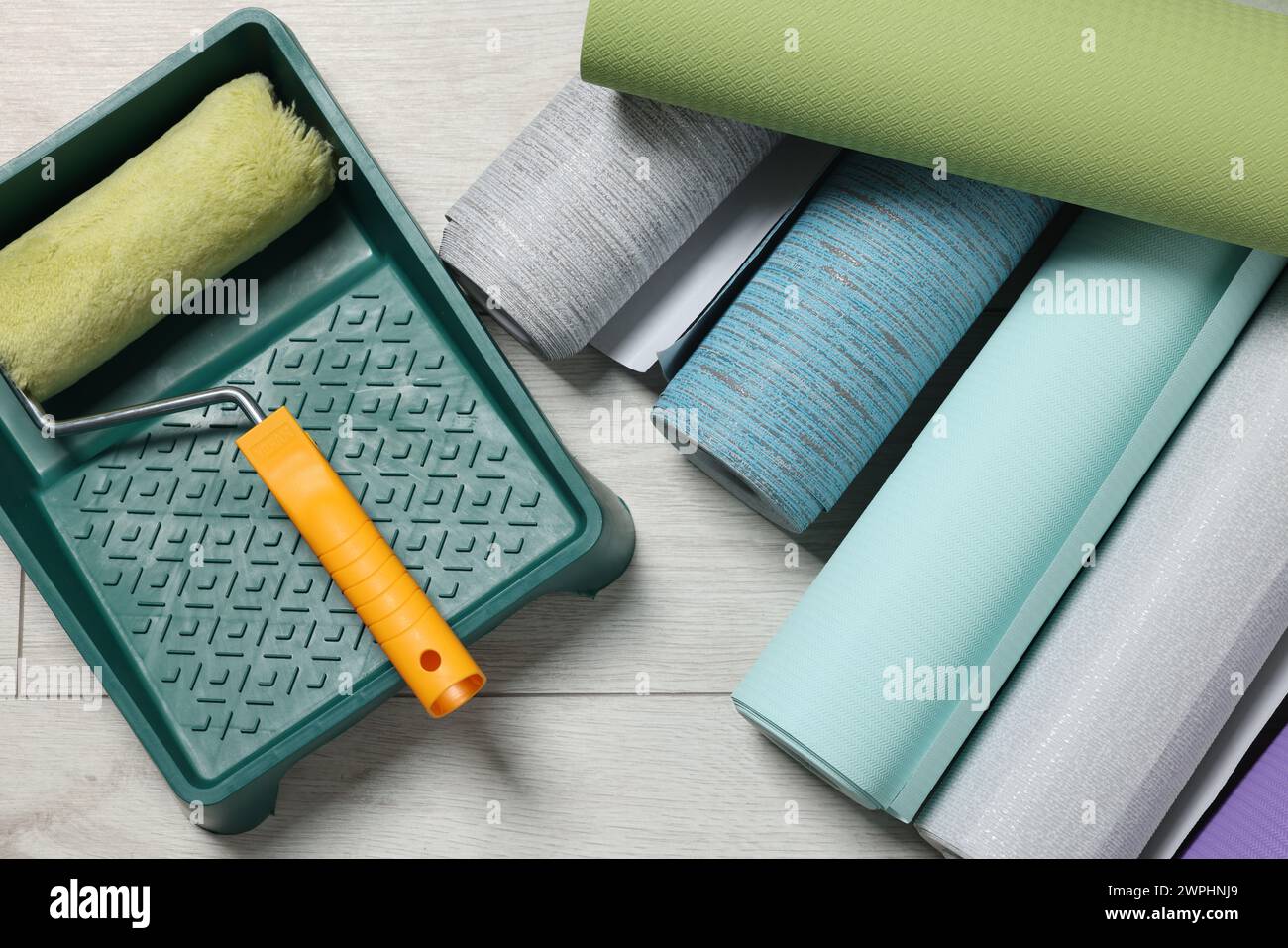 Different wallpaper rolls, roller and tray on floor, top view Stock ...