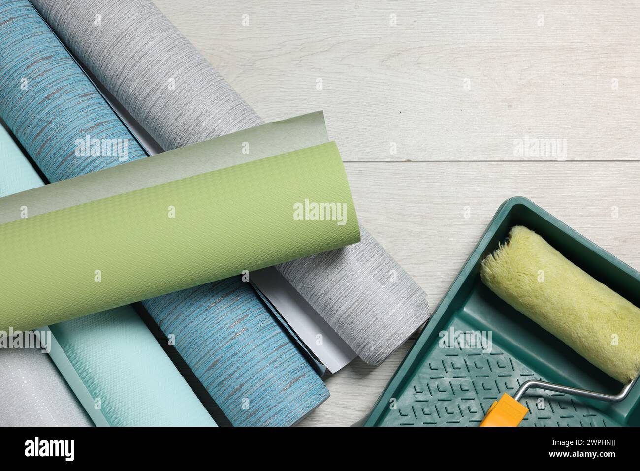 Different wallpaper rolls, roller and tray on floor, top view Stock ...