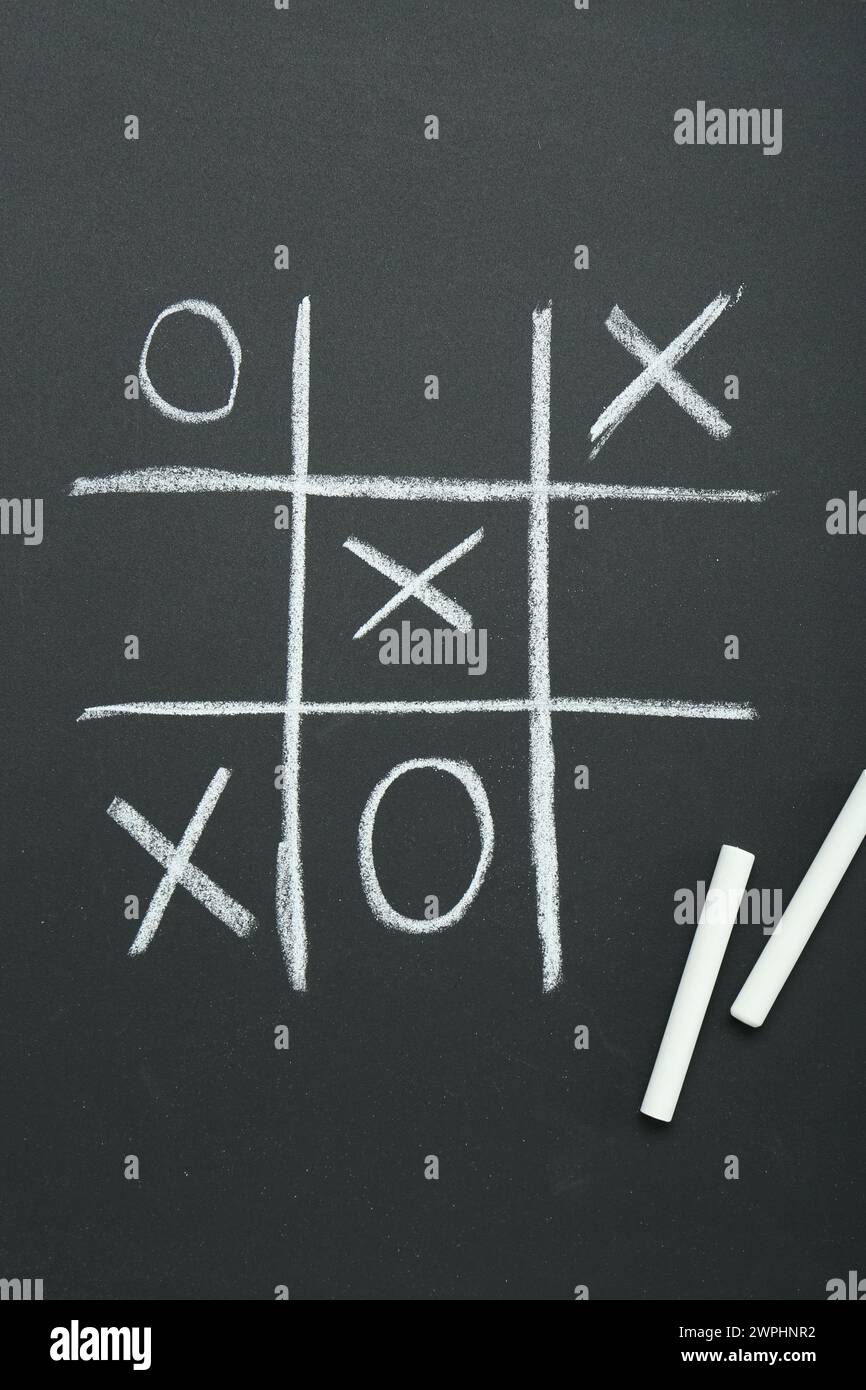 Tic tac toe game drawn on chalkboard, top view Stock Photo - Alamy
