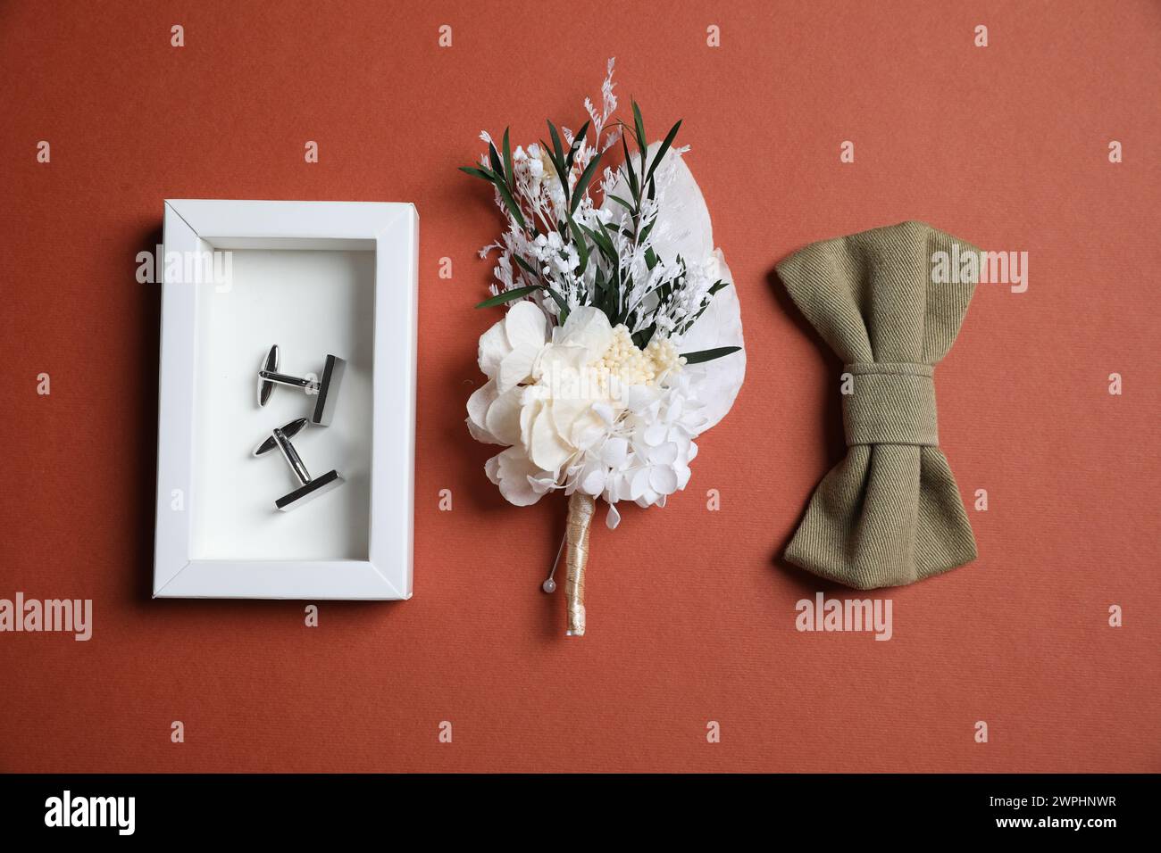 Wedding stuff. Stylish boutonniere, bow tie and cufflinks on brown ...