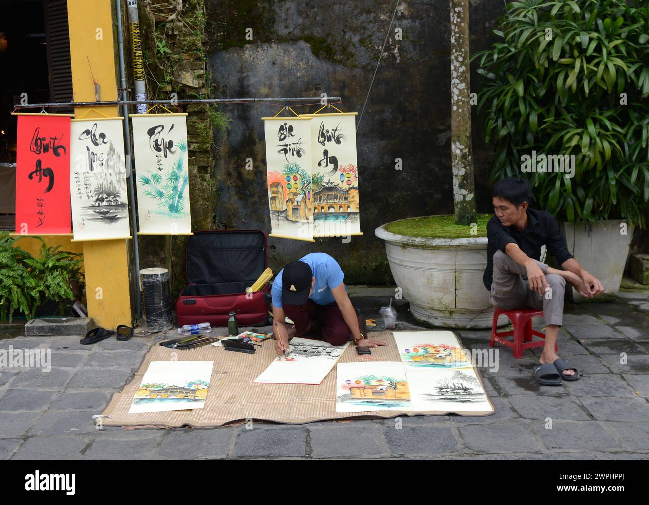 A Vietnamese artist selling his art in the old city of Hoi An, Vietnam Stock Photo - Alamy