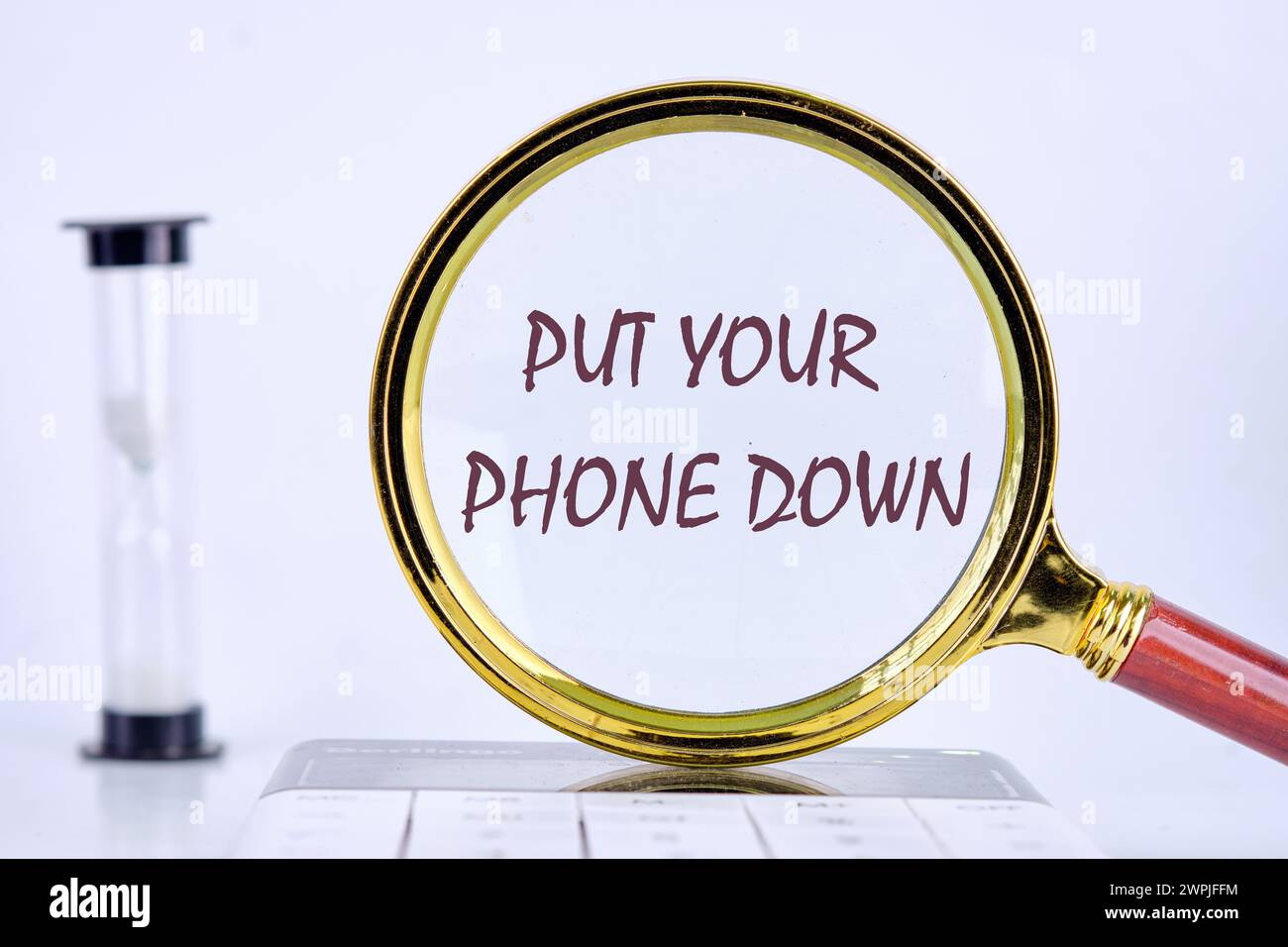 Put Your Phone Down text written through a magnifying glass on a gray ...