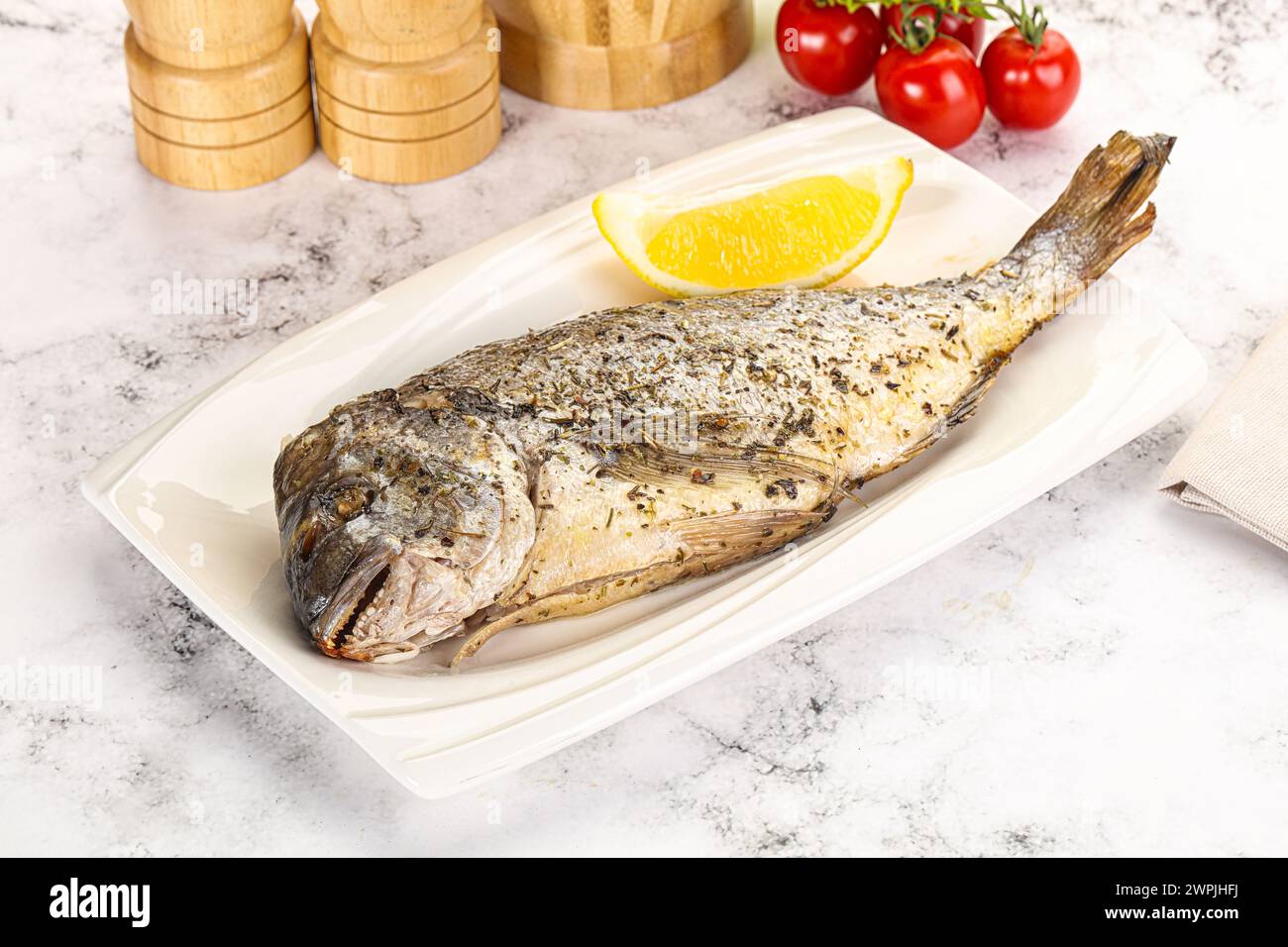 Baked Dorado fish served lemon slice Stock Photo - Alamy