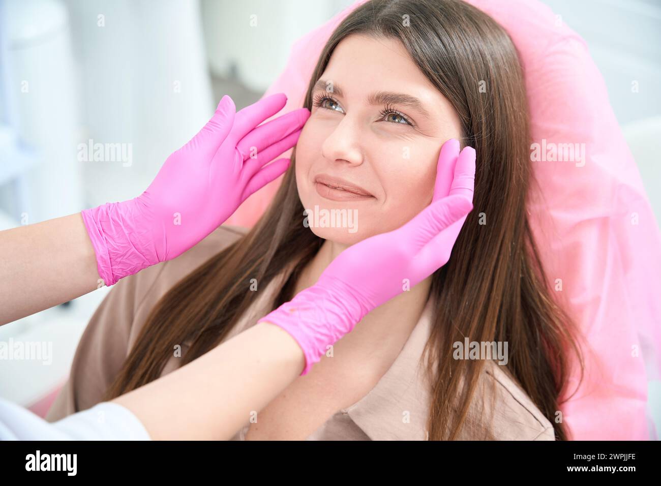 Doctor examine skin of female after procedure Stock Photo - Alamy