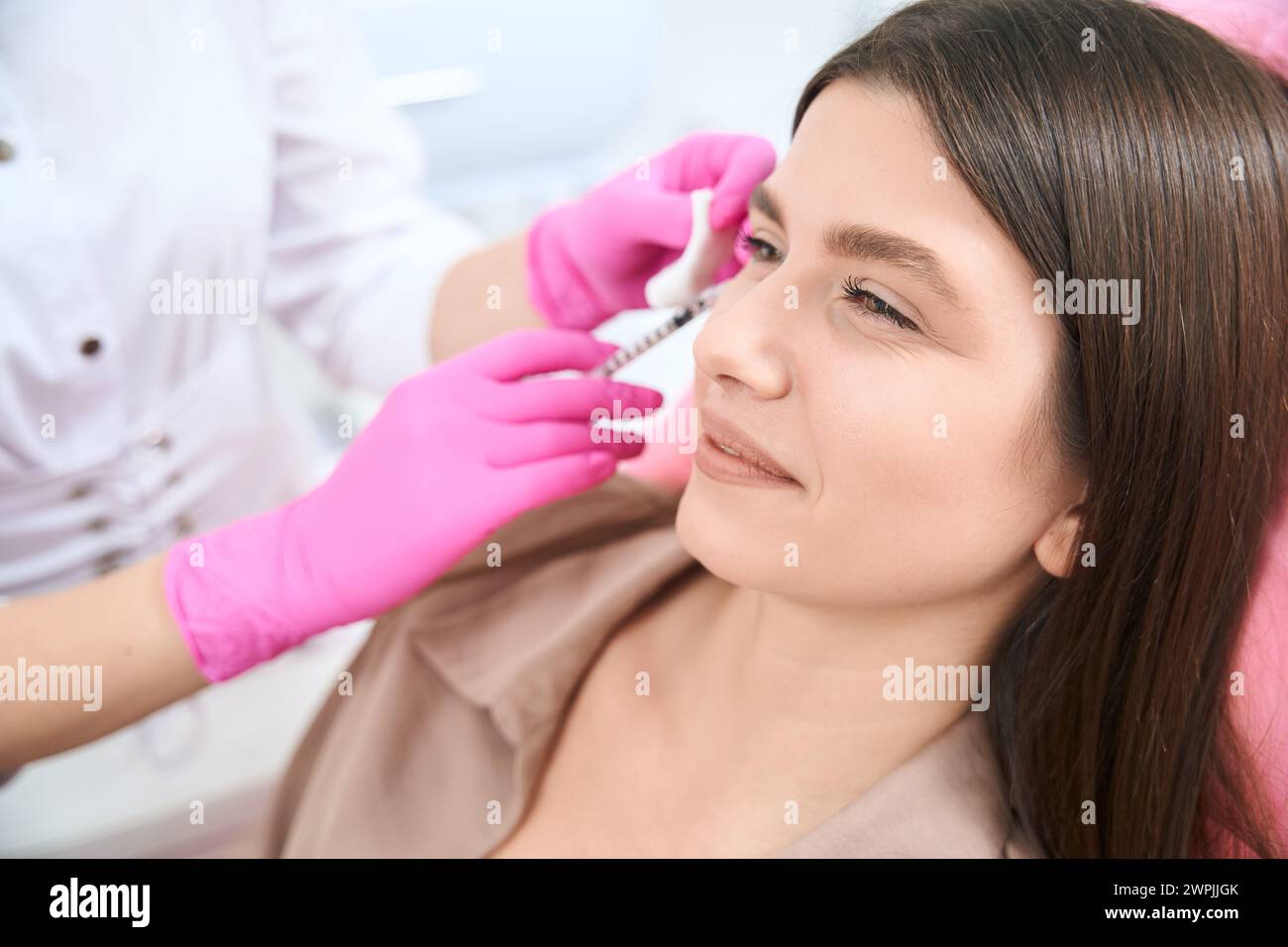 Cosmetician with syringe make face injection to young lady Stock Photo ...