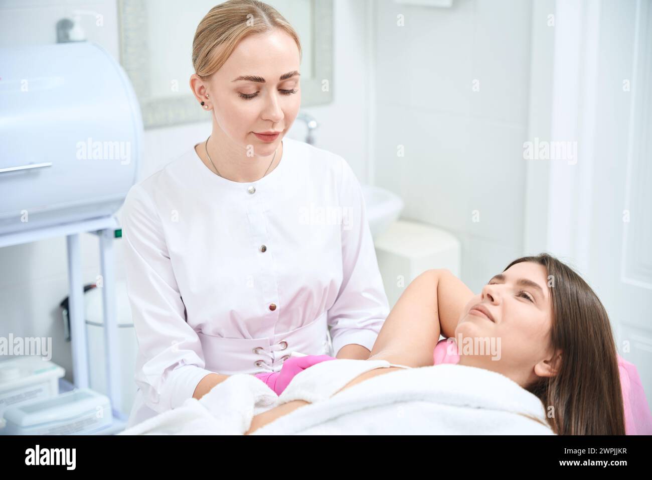 Smiling client on cosmetology procedure for skin with beautician Stock ...