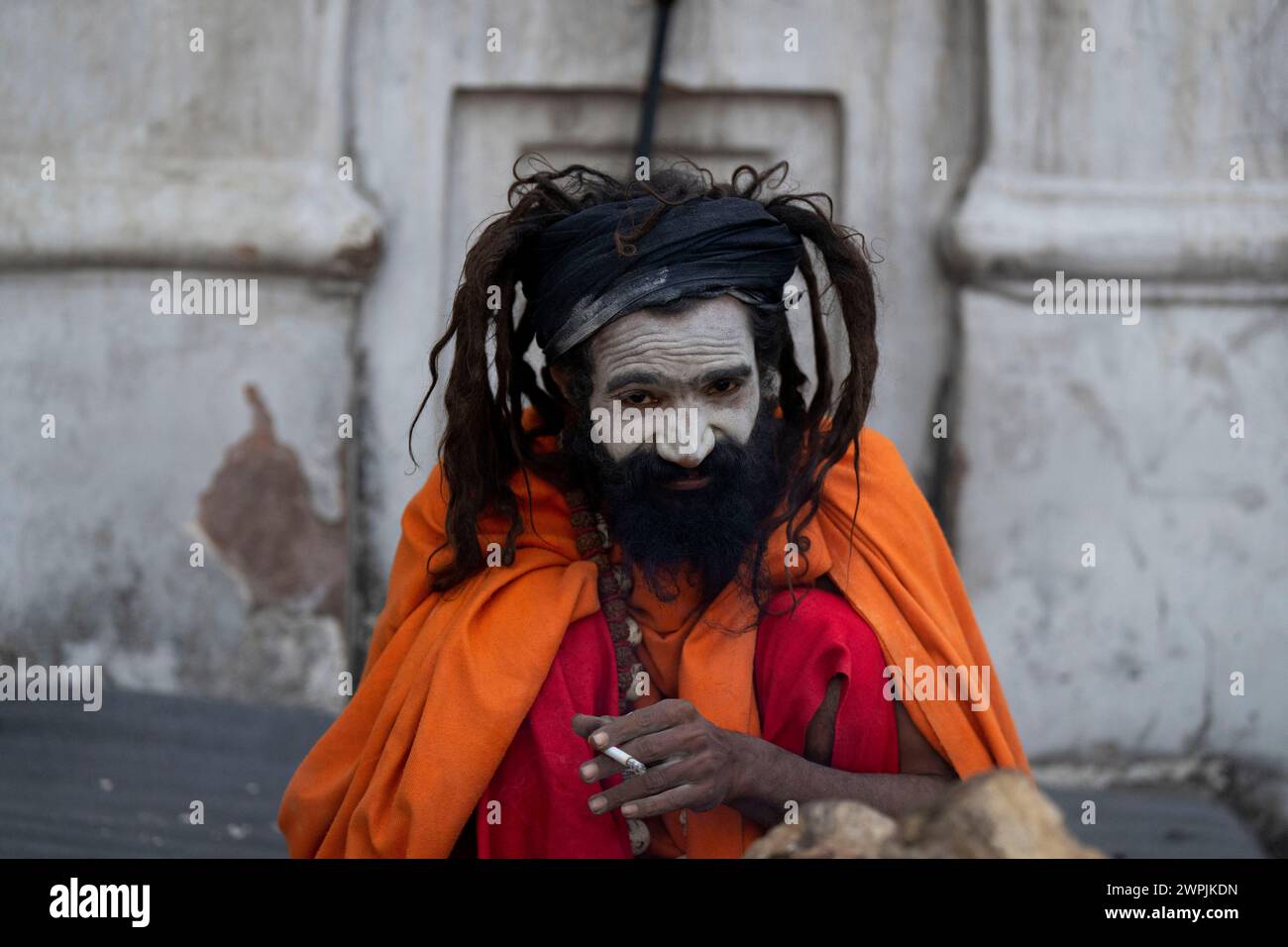 A holy man smokes cigarette at the Pashupatinath temple premises during ...