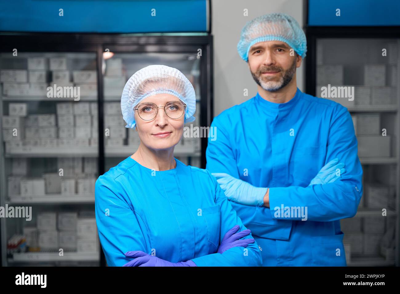 Colleagues laboratory assistants in blue uniforms stand in the ...