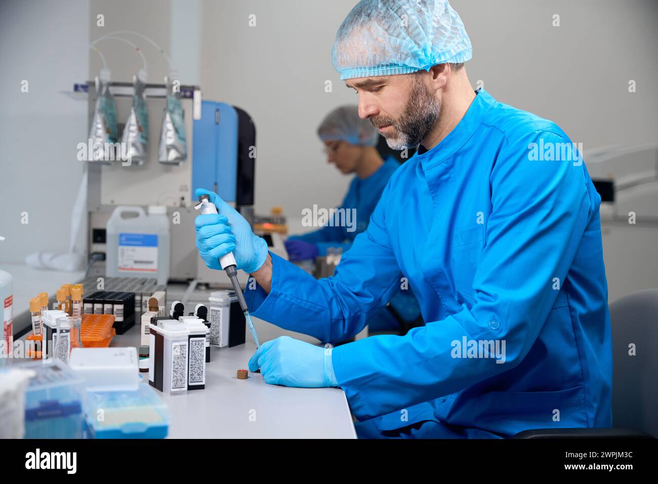 Male laboratory assistant examines biological material in a modern ...