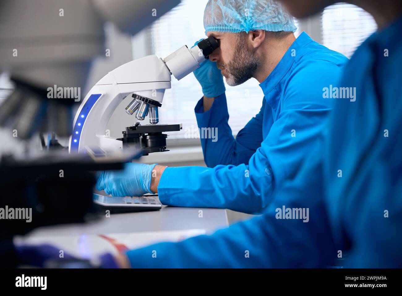 Middle-aged male uses a powerful microscope Stock Photo - Alamy