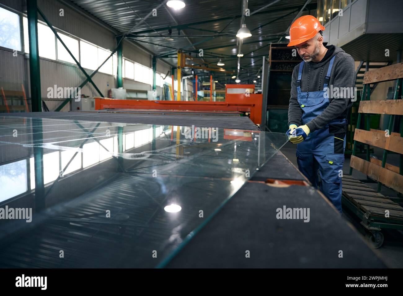 Worker cuts glass for a double-glazed window Stock Photo - Alamy