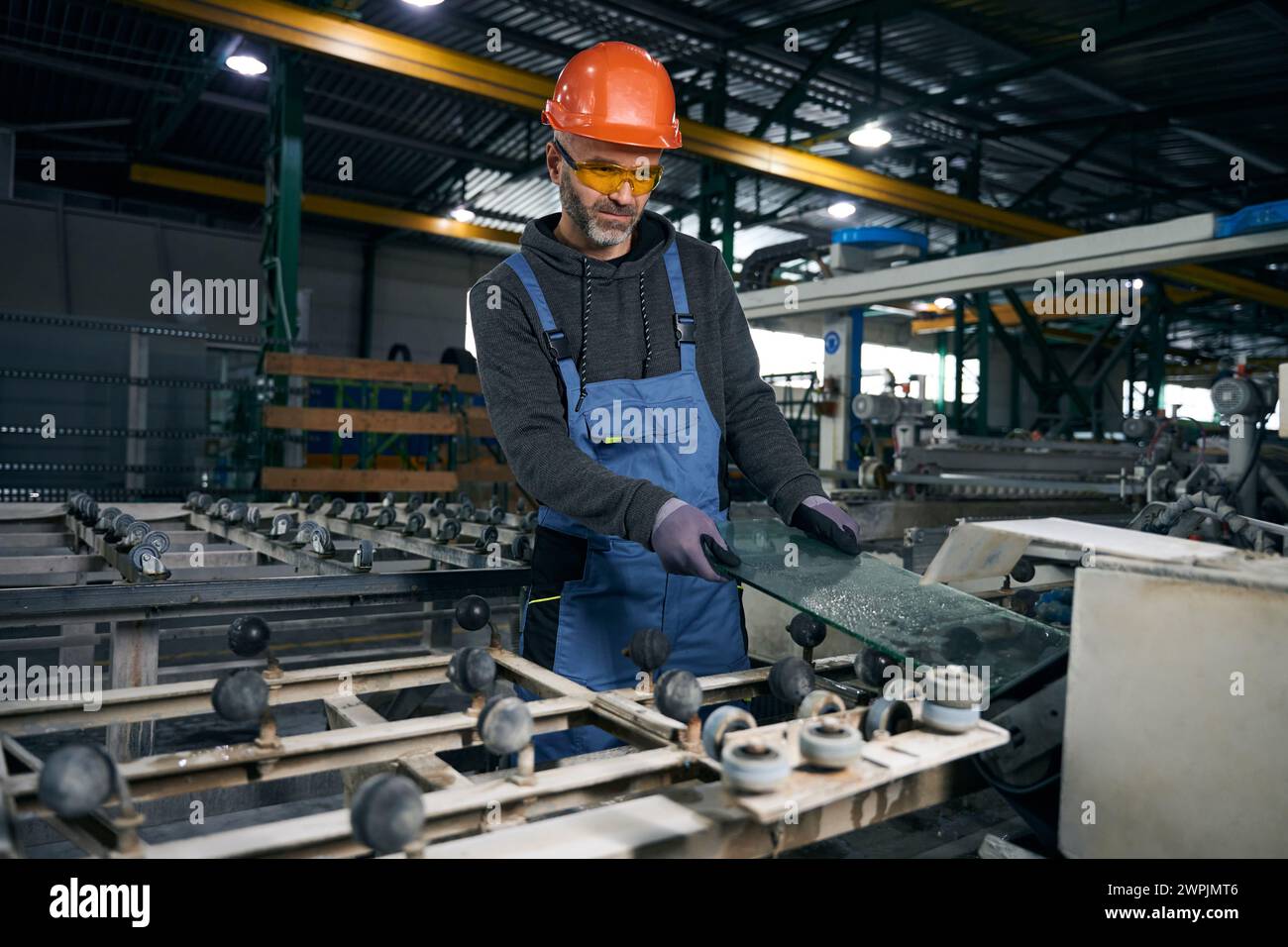 Master in a window production processes the edges of glass Stock Photo ...