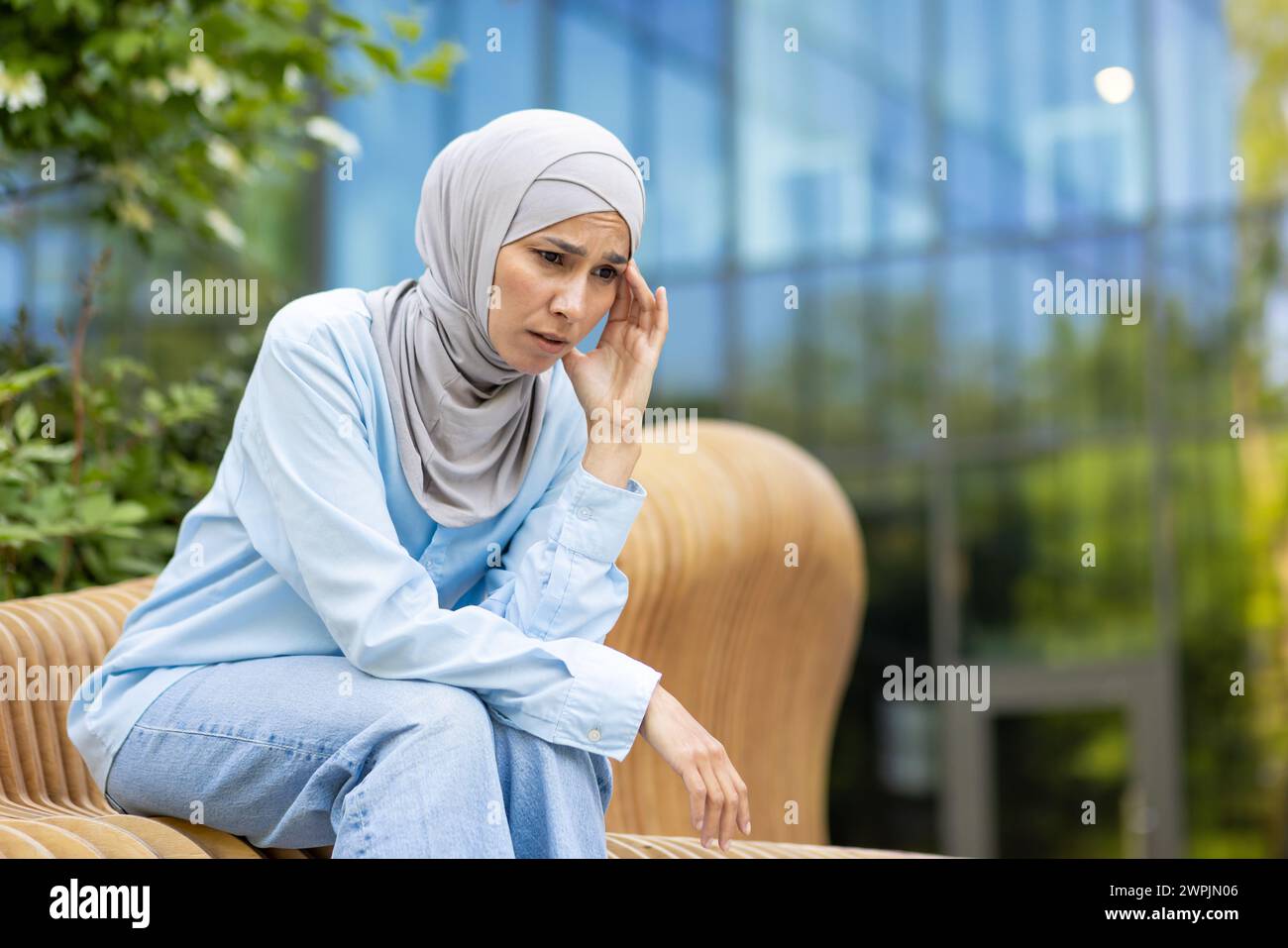 A Muslim woman in a hijab appears troubled or contemplative while ...