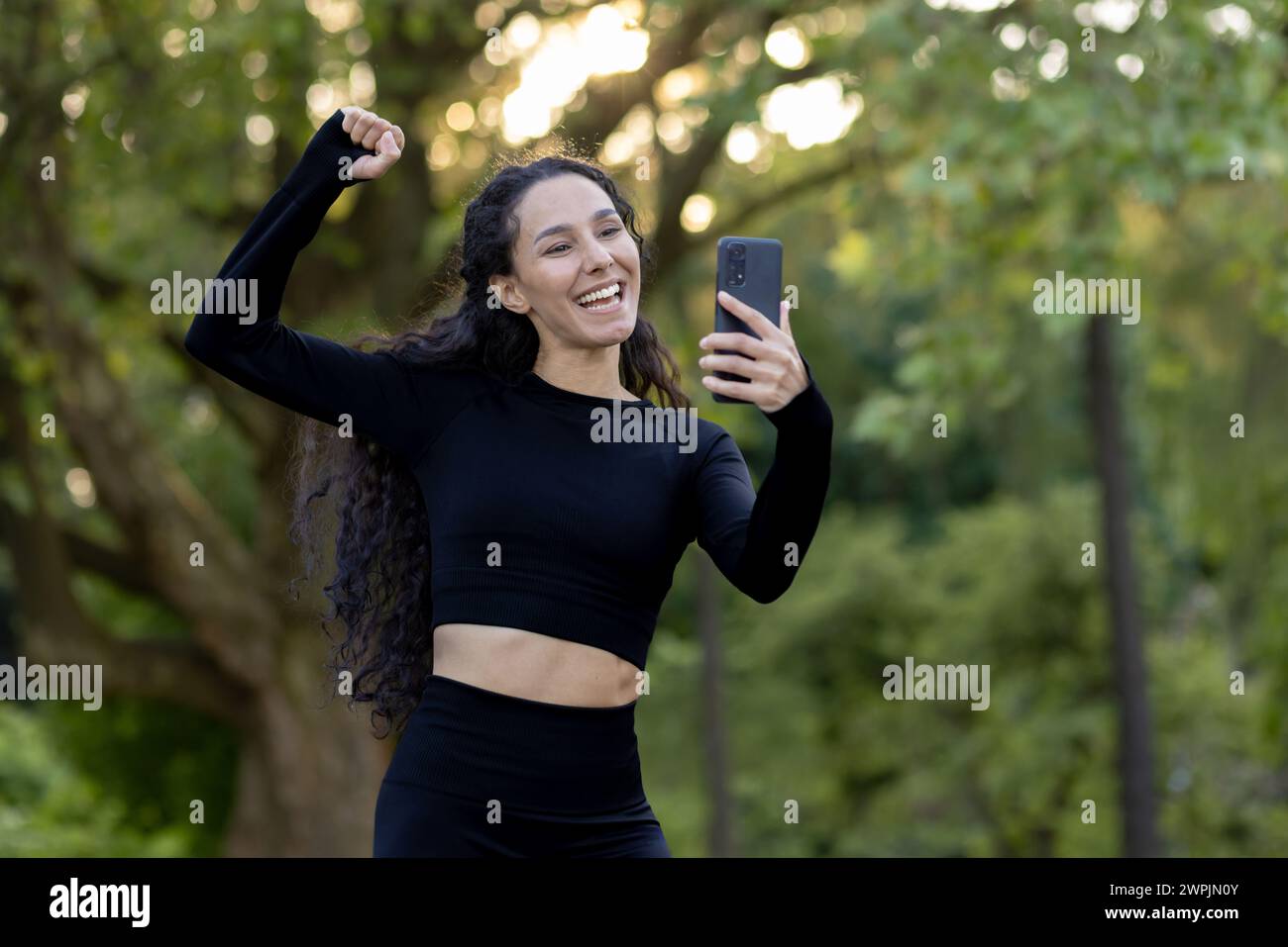 Smiling, active female in athletic attire captures a cheerful moment on ...