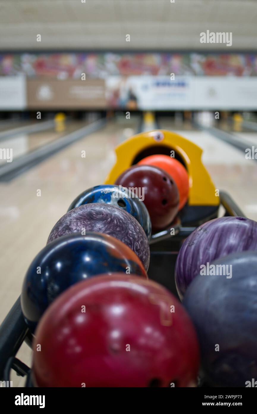 Colorful bowling balls in return machine at bowling alley. Lanes and ...